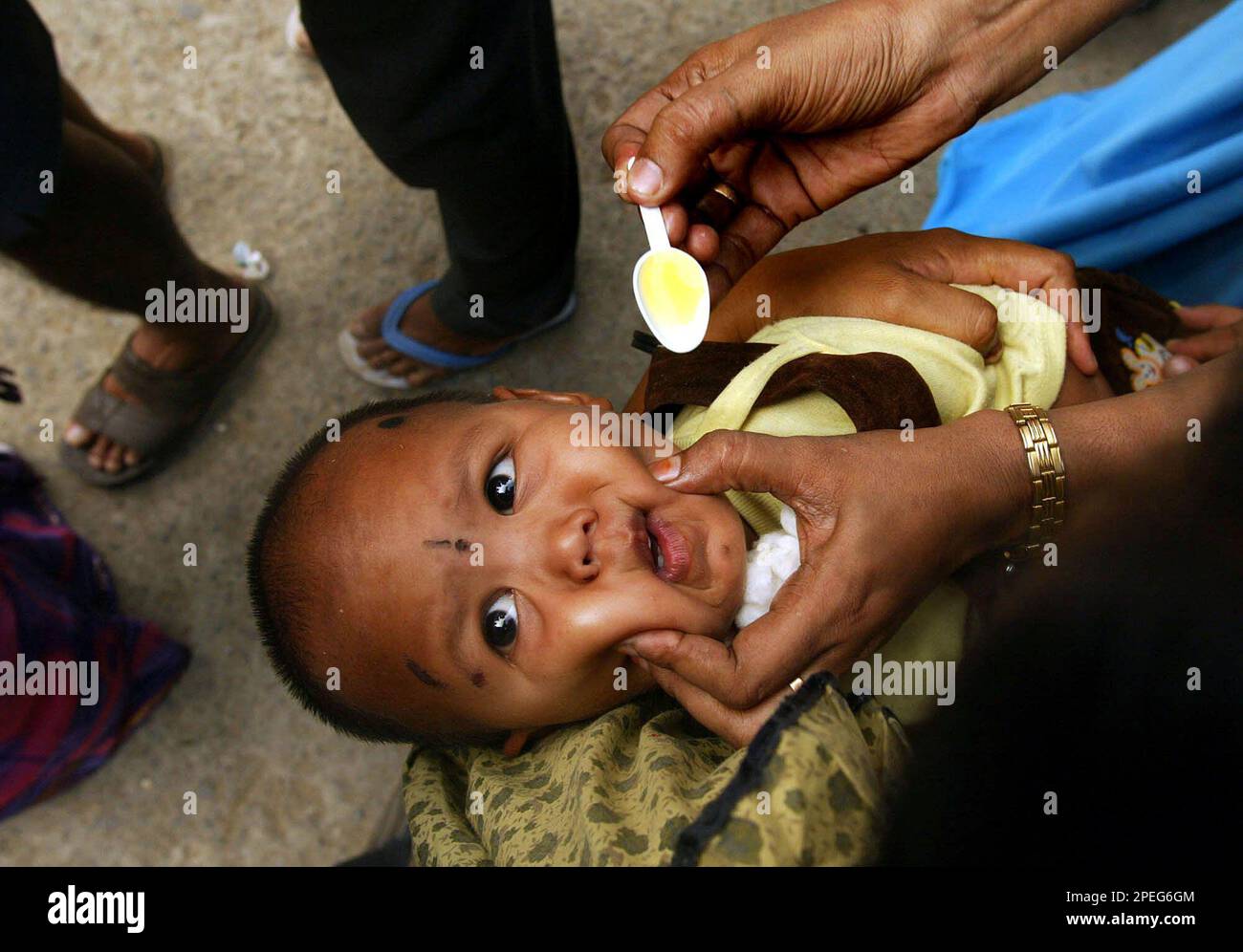A UNICEF volunteer administers vitamin A syrup to a boy from Nicobar ...