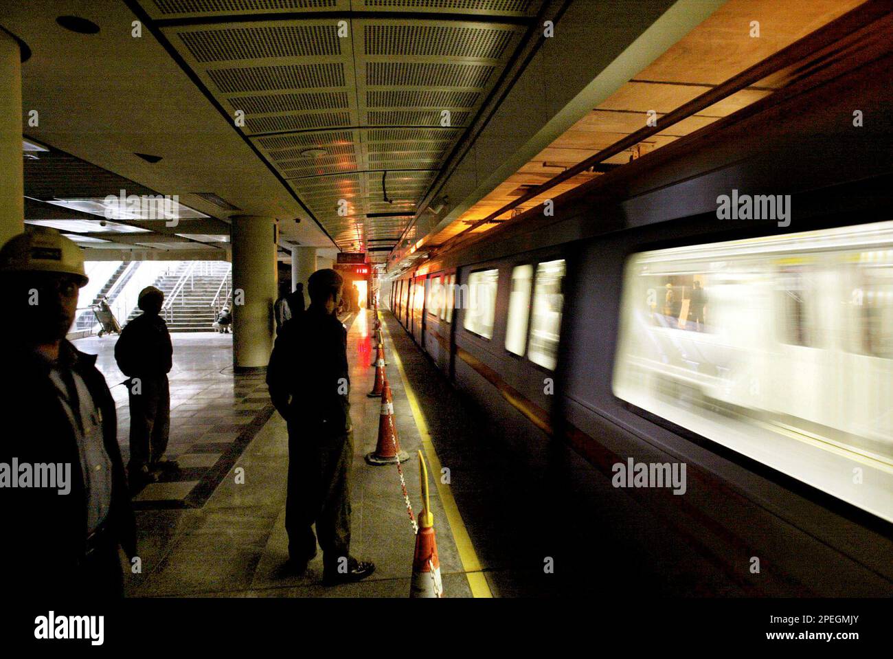Delhi Metro Rail Corporation (DMRC) workers watch the trial run of a ...