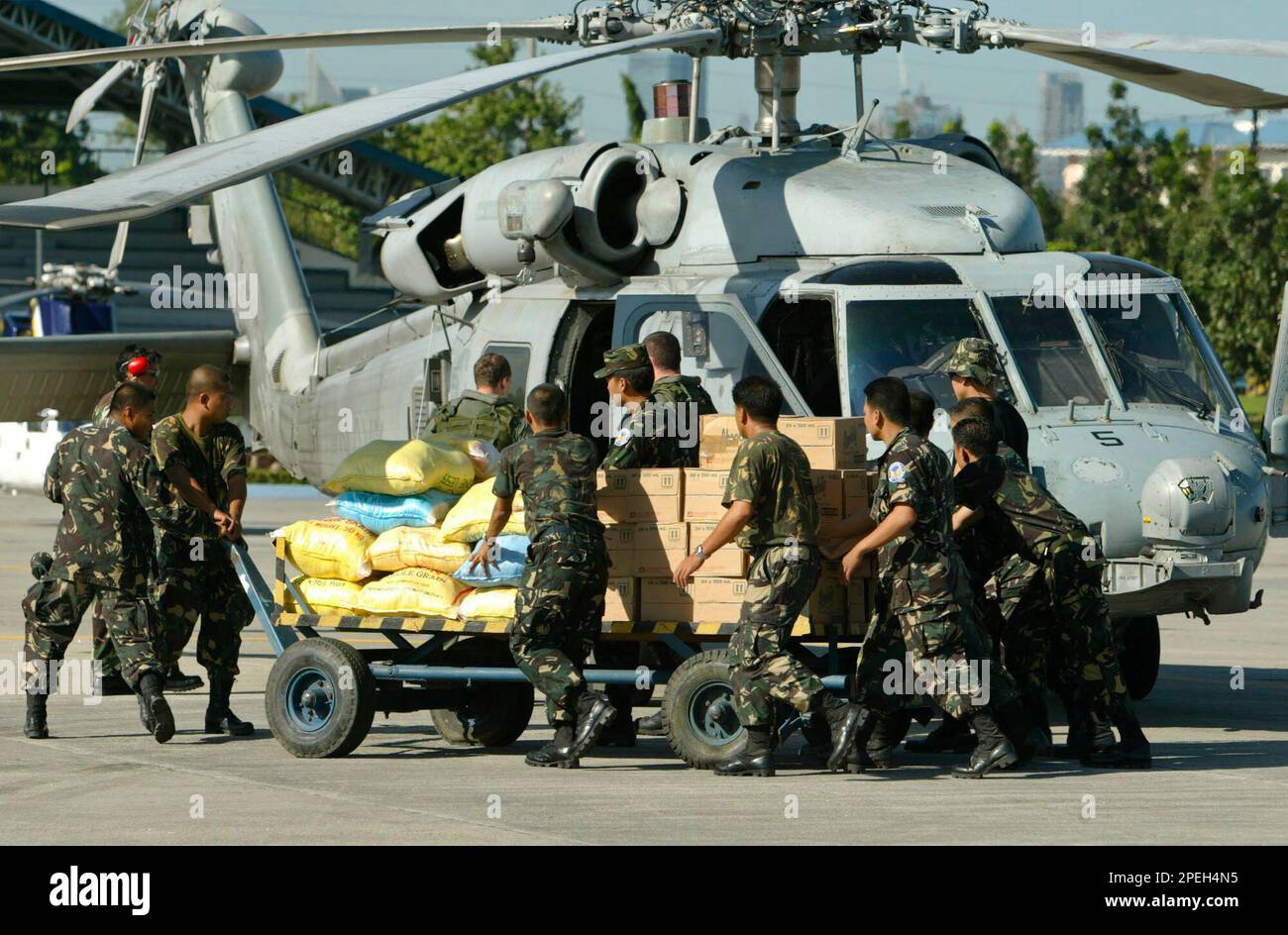 Filipino soldiers load relief supplies onto a US Navy HH-60 Seahawk ...