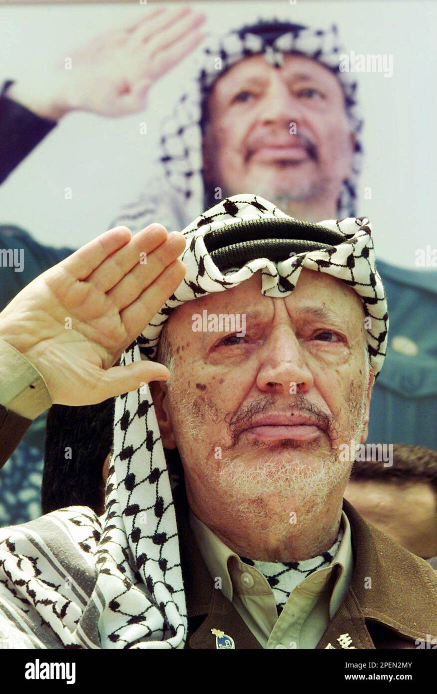 Palestinian leader Yasser Arafat salutes as he stands in front of a ...