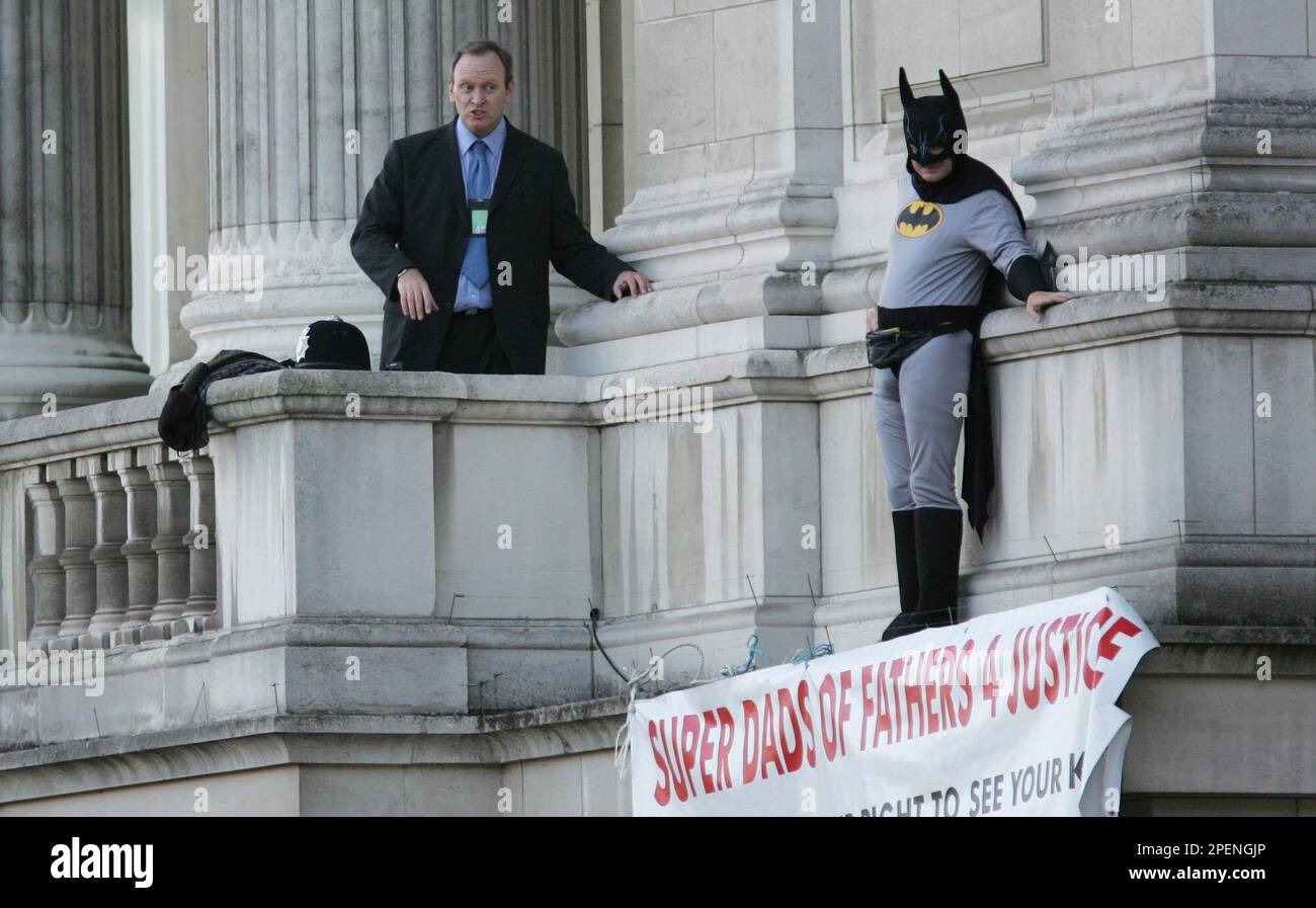 A man dressed in a 'Batman' suit is looked at by a member of Buckingham ...