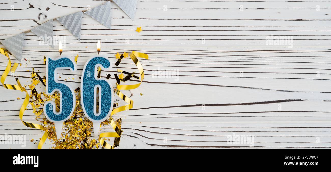Bougie de célébration bleue numéro 56 sur fond blanc en bois. Joyeux ...
