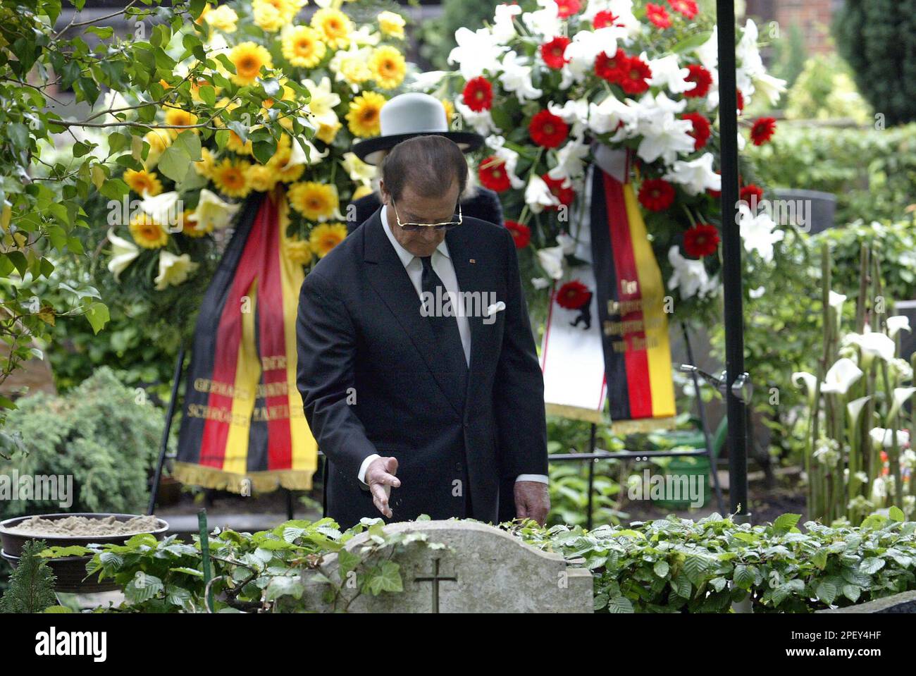 Der britische SchauspielerSir Roger Moore streut Sand in das Grab des ...