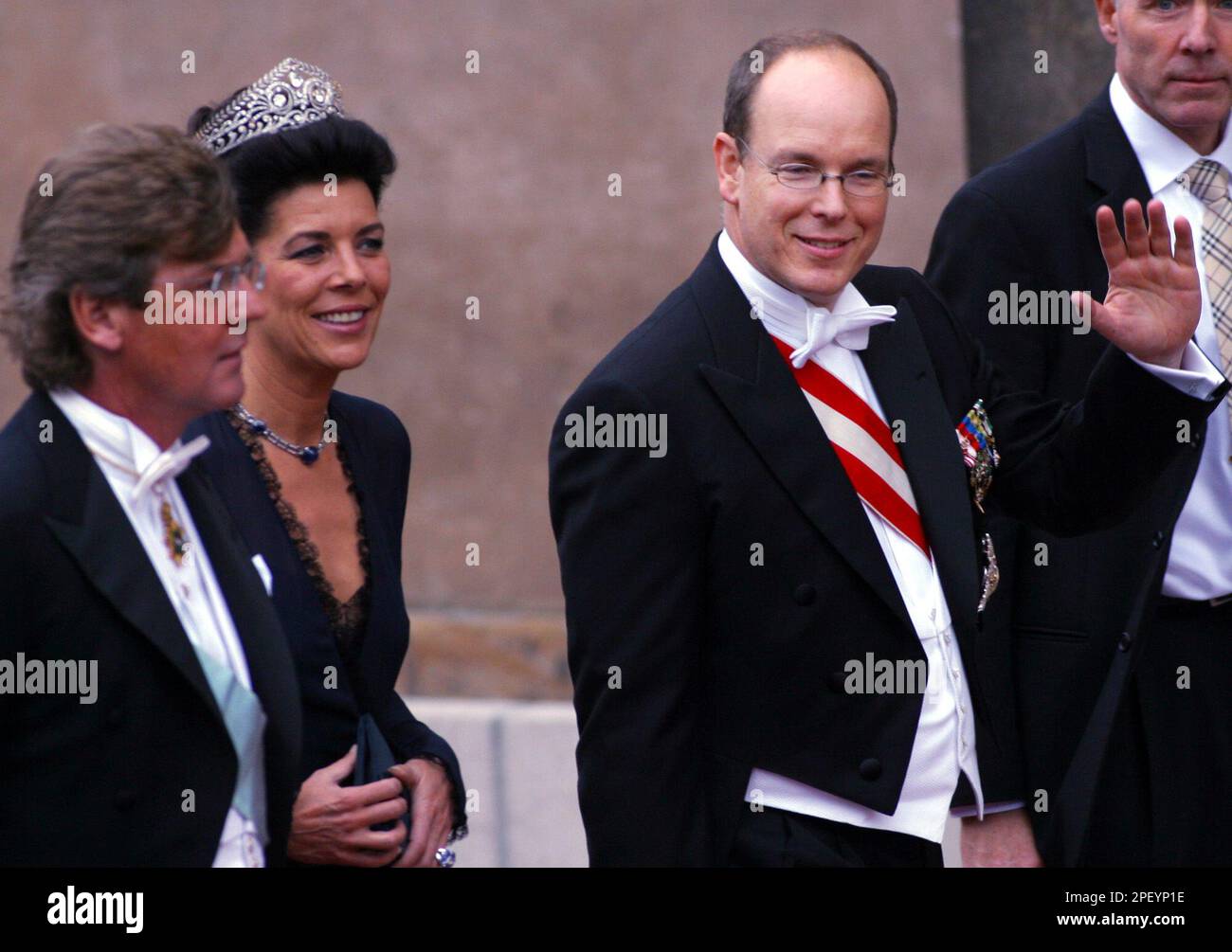 Prince Albert of Monaco, right, waves while arriving with his sister ...