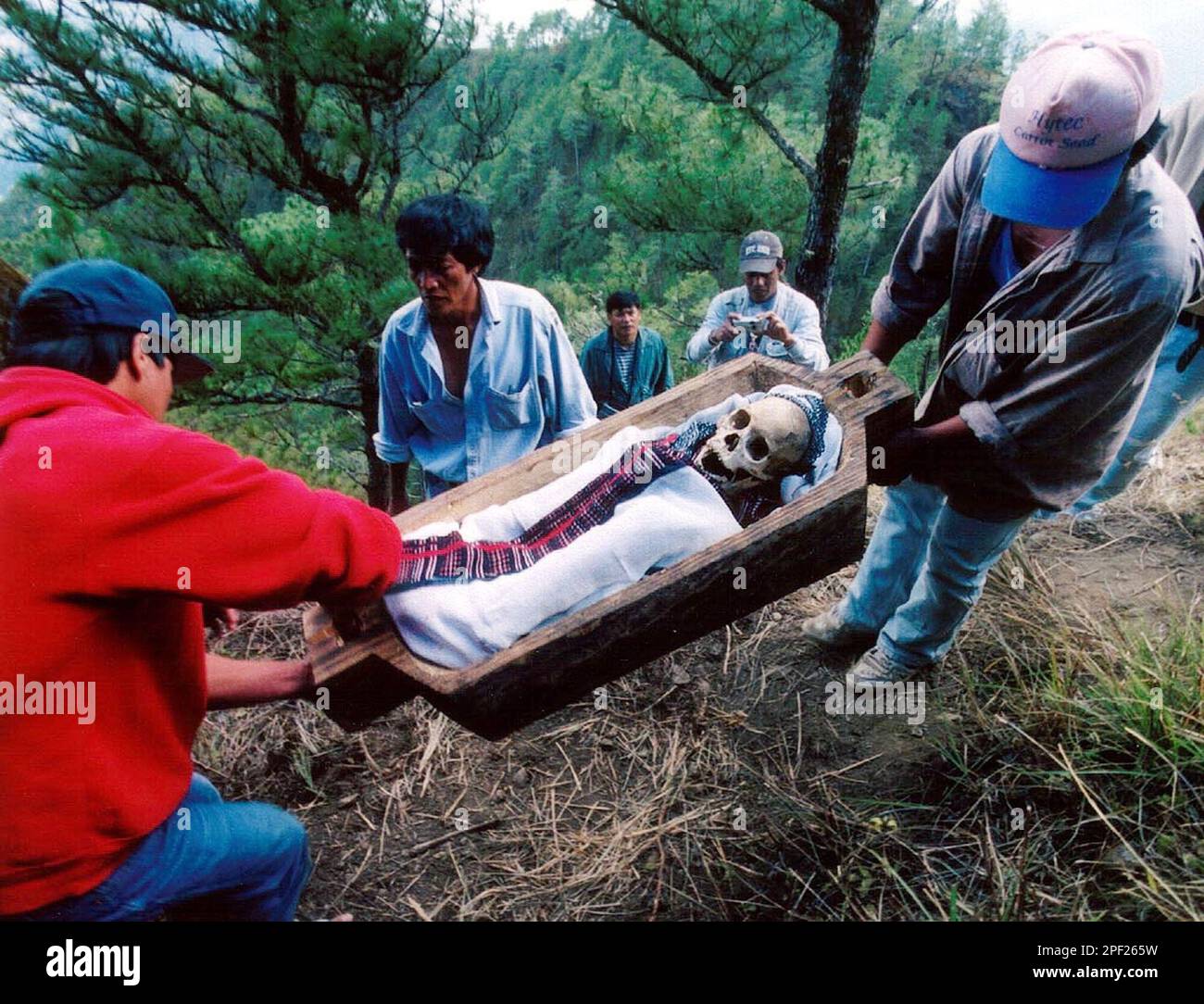 Filipino tribesmen carry a mummy before it is returned to burial cave ...
