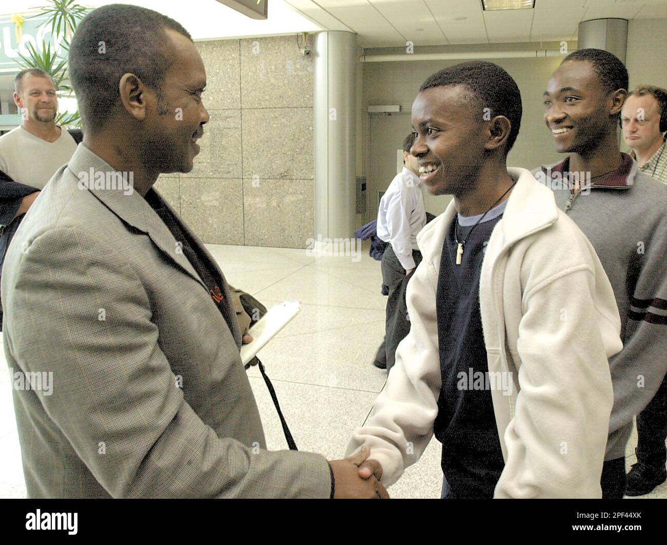 Damas Gisimba, left, greets Alex Nsengimana, center, and Alphonse ...