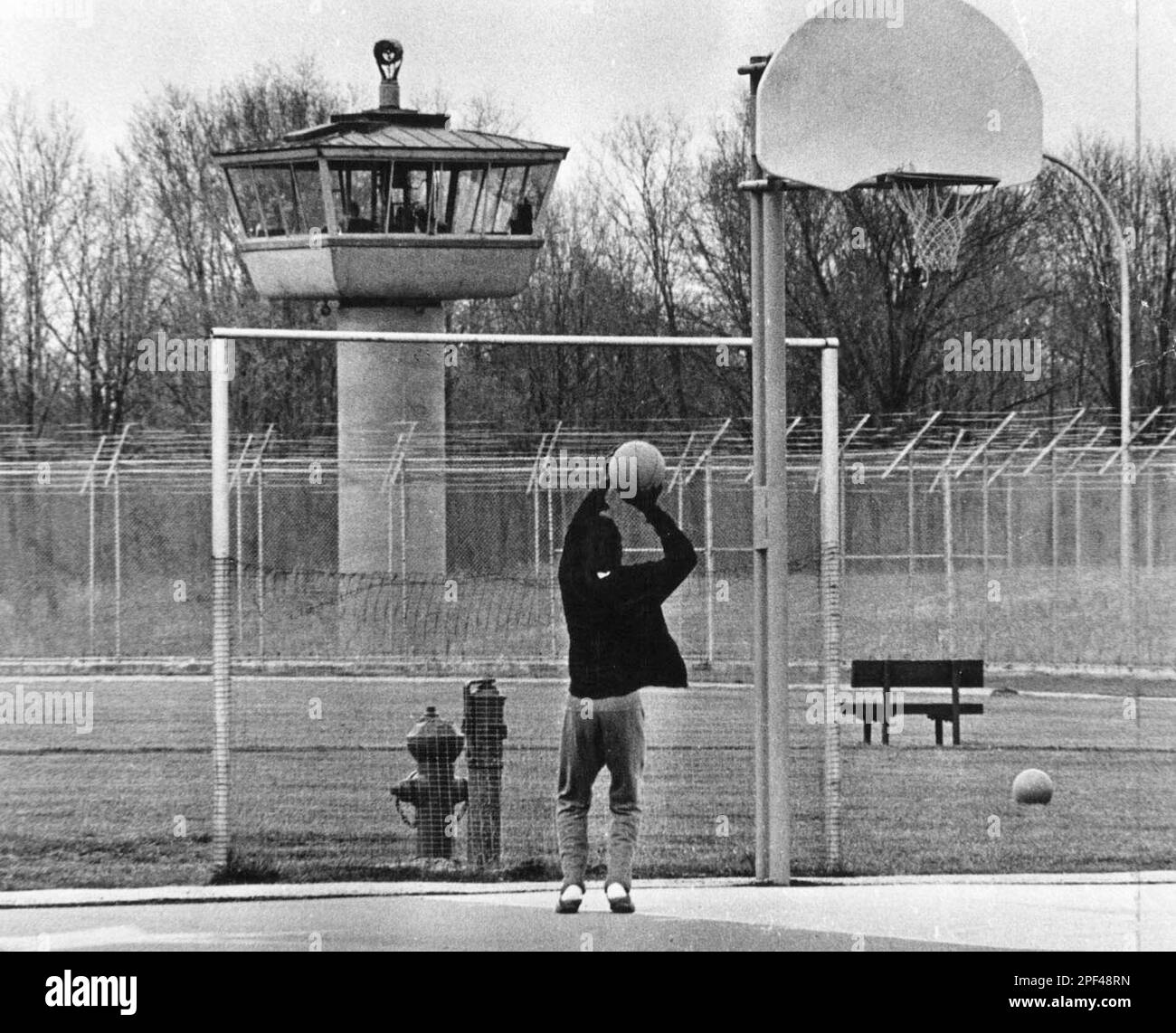 ** FILE ** An inmate shoots baskets in the recreation yard at the ...