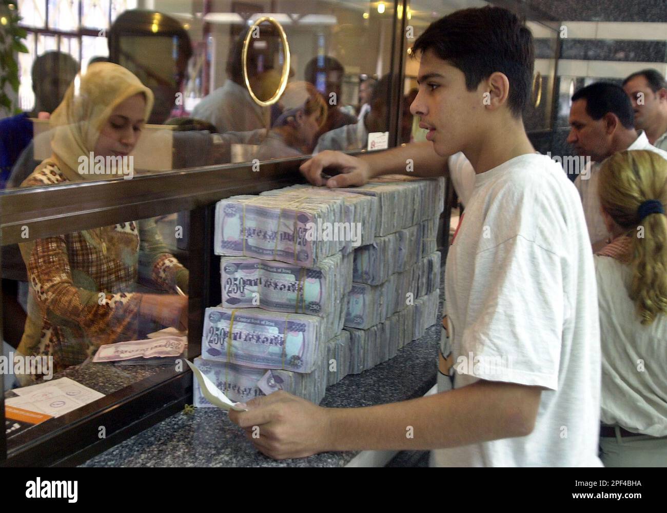 An Iraqi exchanges old currency at a bank in Baghdad, Wednesday 15 Oct ...