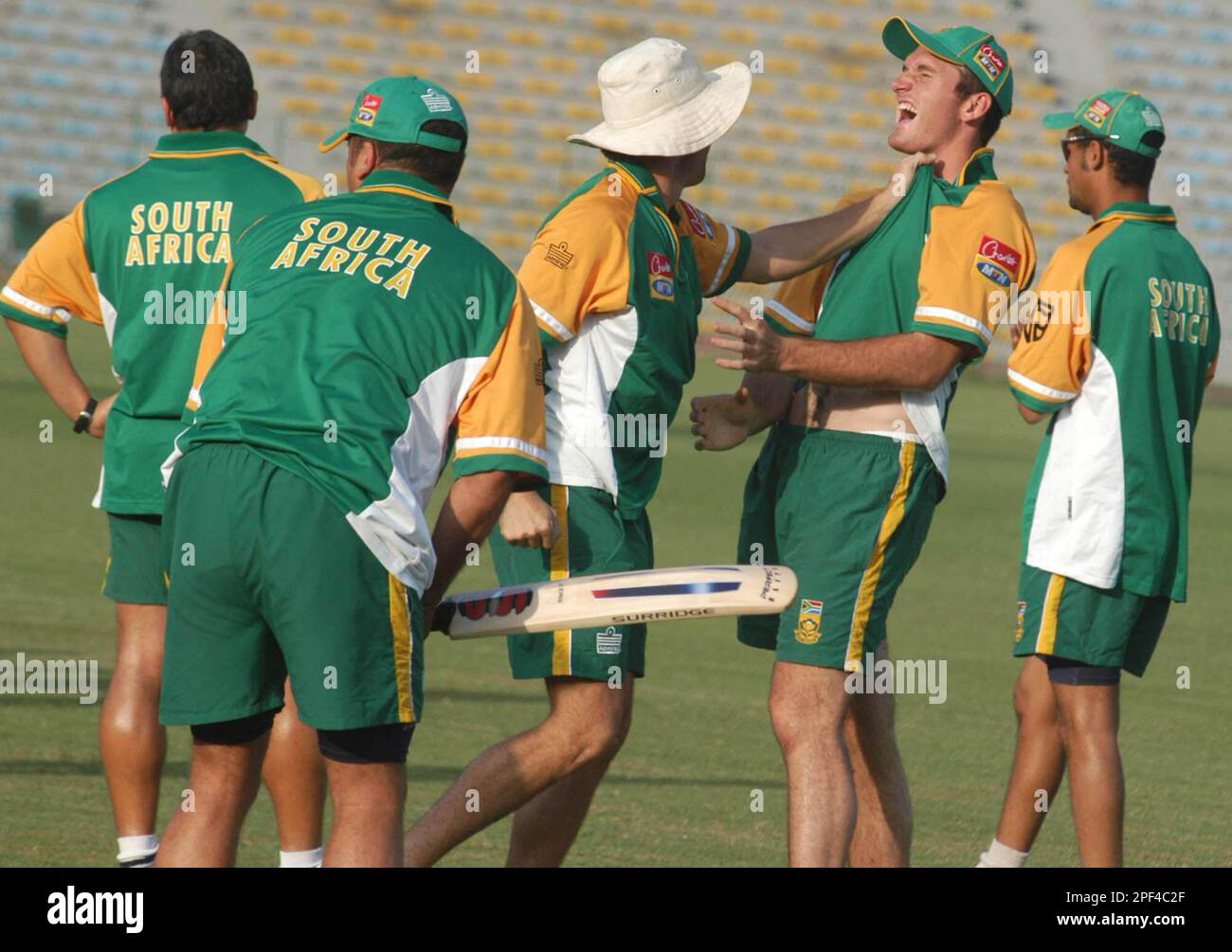 South African player Neil McKenzie, in a white cap, plays with captain ...