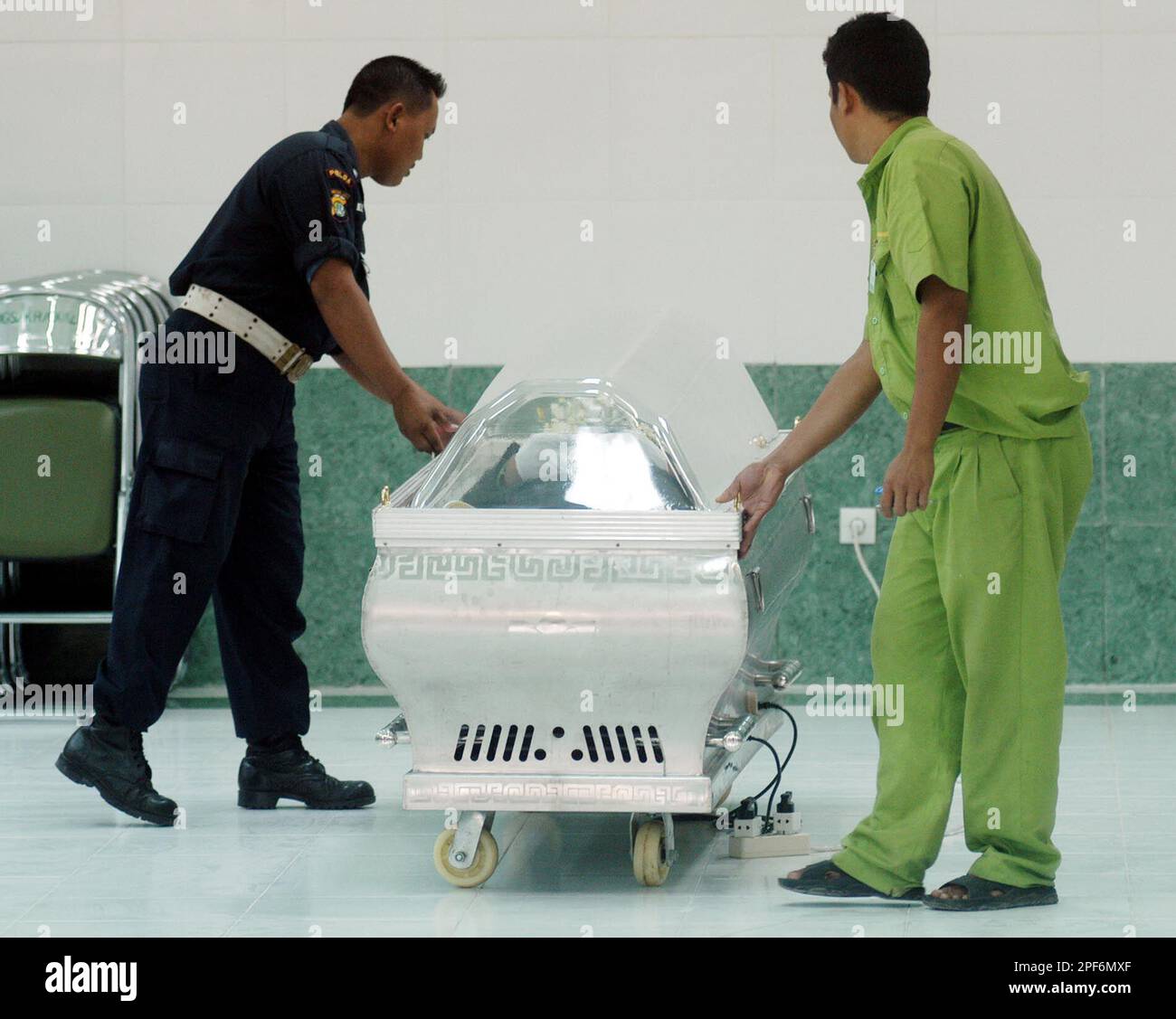 Hospital employees inspect the casket containing the body of german ...