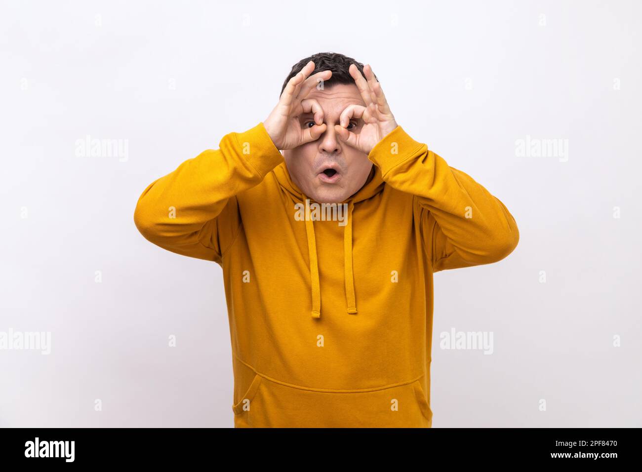 Portrait d'homme curieux regarde à travers les doigts dans le mouvement ...