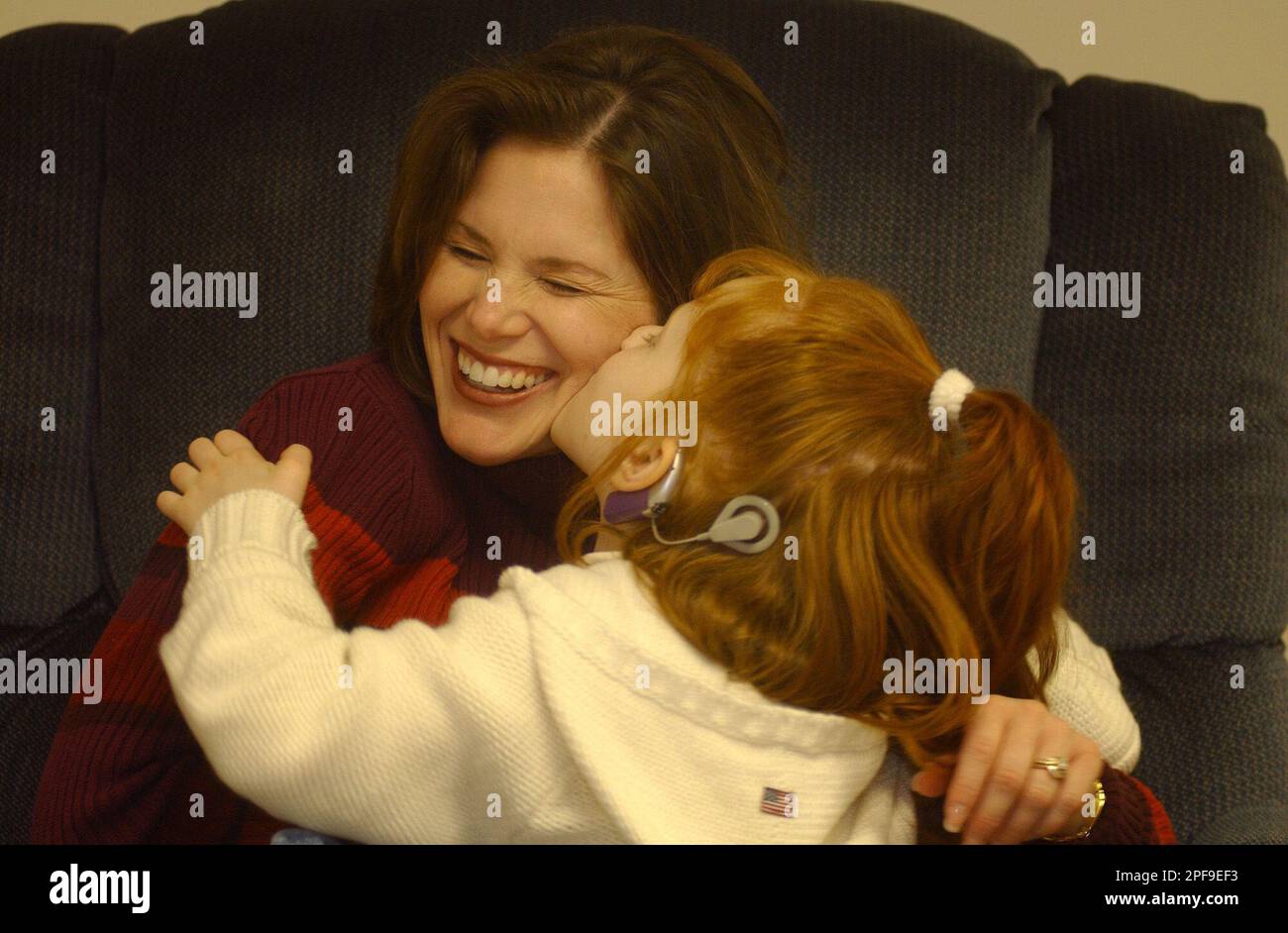 Angie King gets a kiss from her daughter Erica, 6, at their home in ...