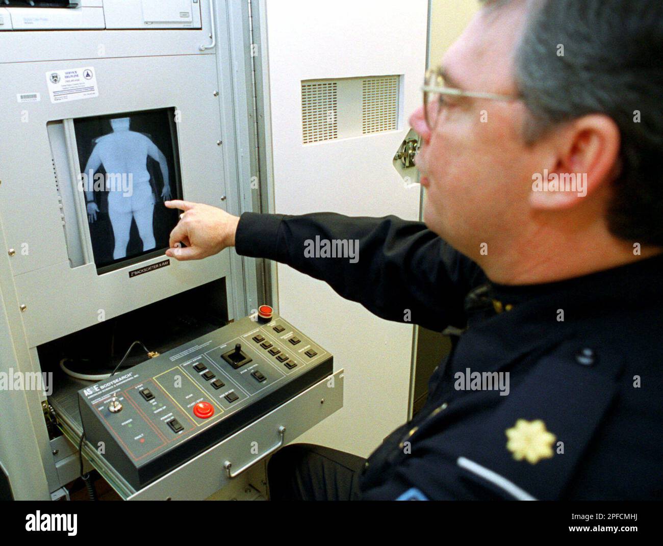 Inspector Bill Desmond points to an object hidden under clothing during ...