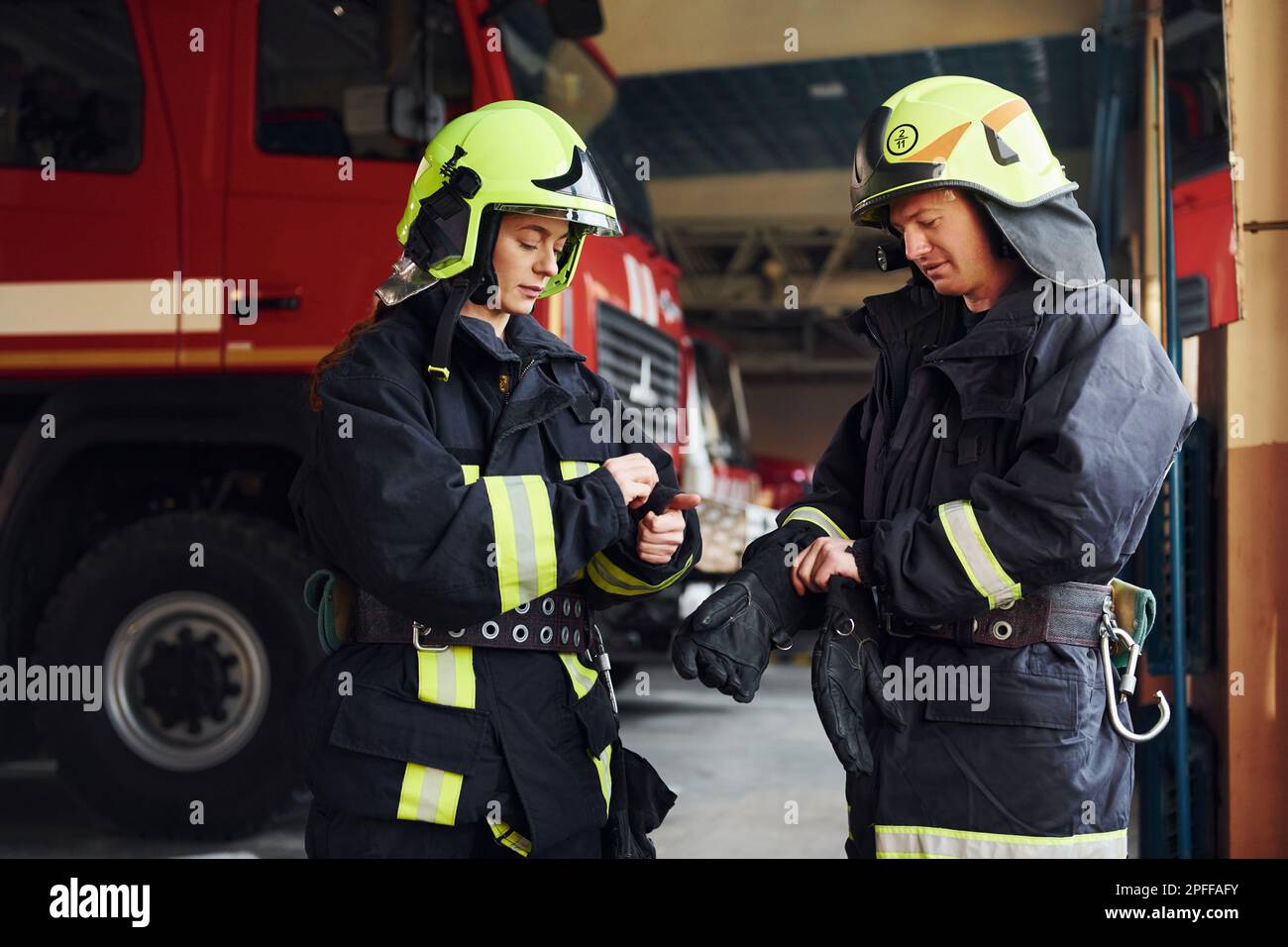 Pompiers hommes et femmes en uniforme de protection debout ensemble ...