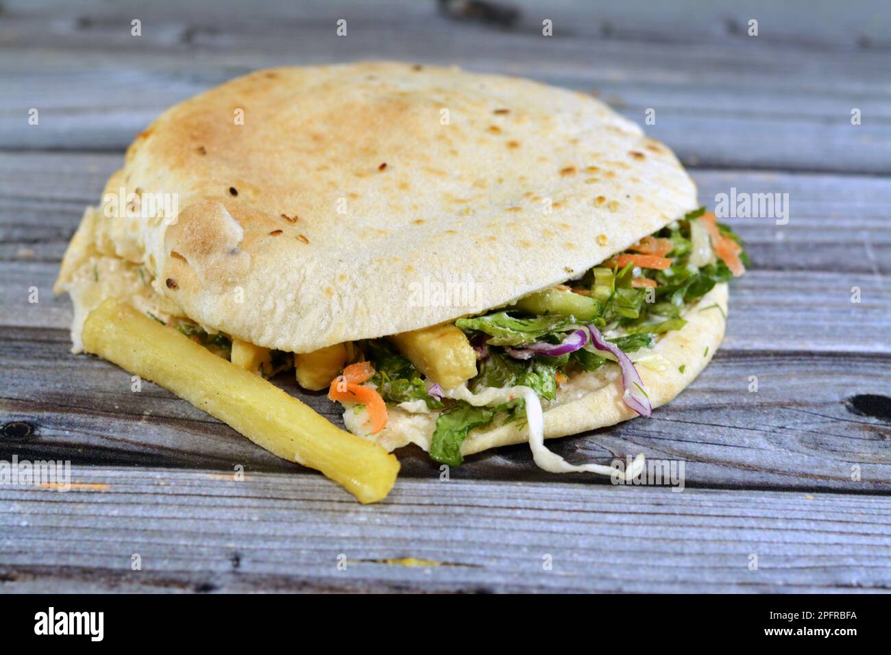 Pain syrien plat Shami rempli de frites et de salade verte, sandwich ...