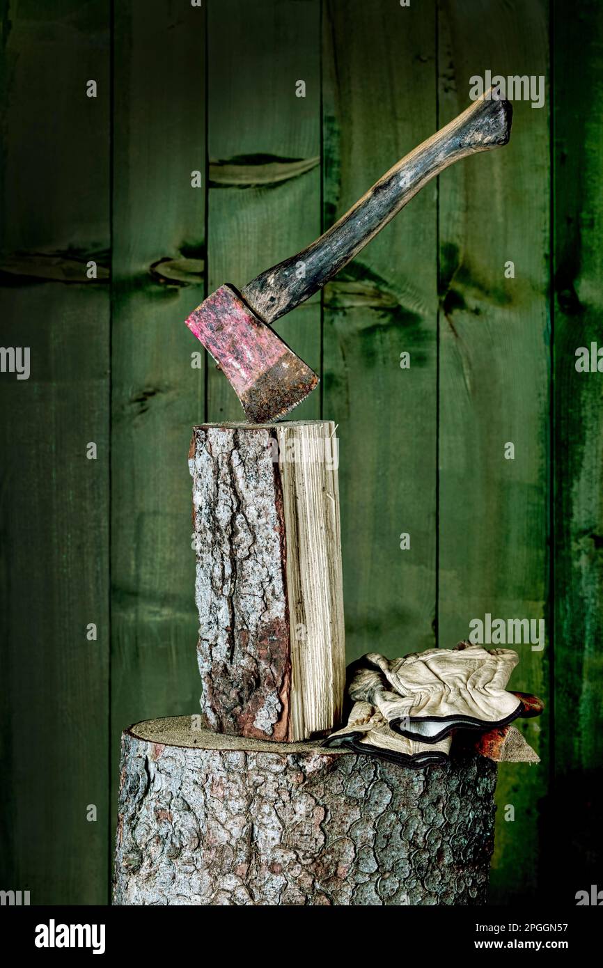 Hache sur bloc de hachage avec une bûche devant un mur en bois vert ...