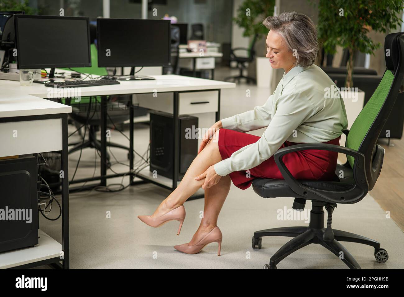 Une femme caucasienne massait ses jambes fatiguées en étant assise au ...