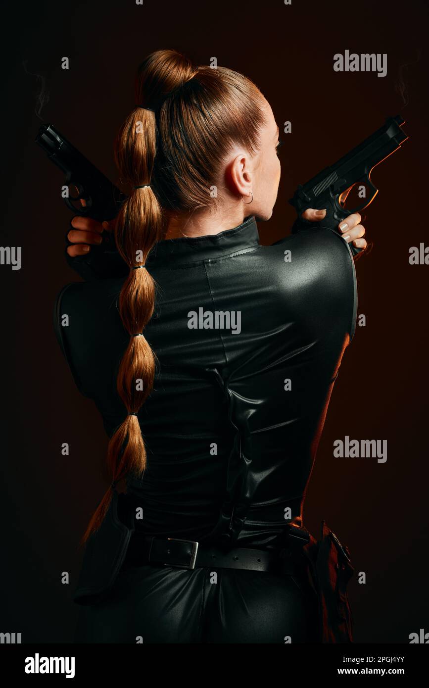 Femme, arme à feu et assassin en studio avec dos, costume et action ...