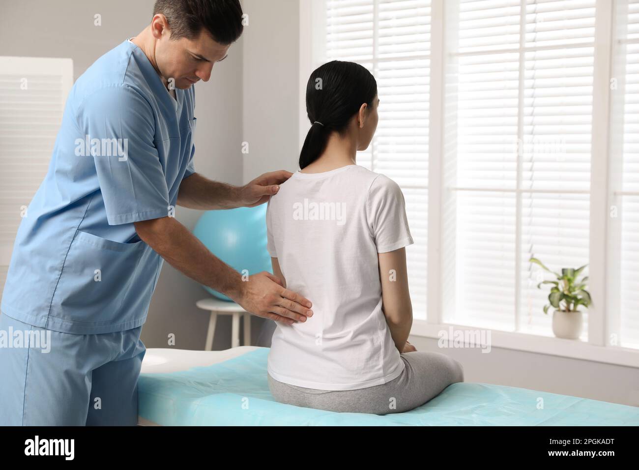Orthopédiste examinant le retour de la femme en clinique. Traitement ...