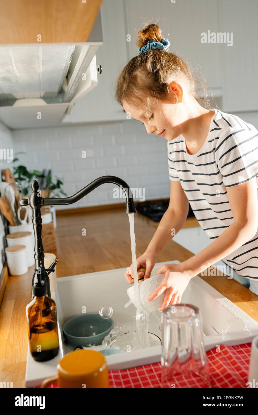 Girl washing dishes at home Banque de photographies et d’images à haute ...
