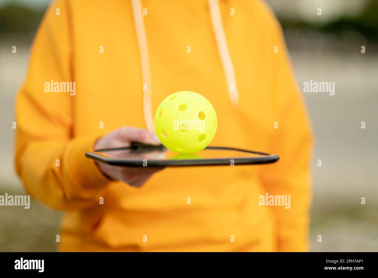 Pickleball paddle et le ballon jaune gros plan, femme jouant au jeu de ...