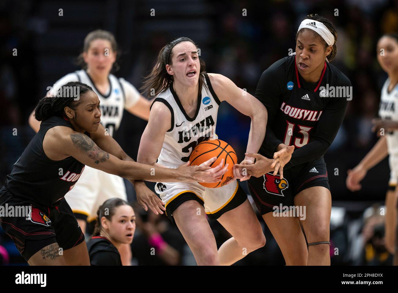 Iowa guard Caitlin Clark, center, fights Louisville forward Nyla Harris ...