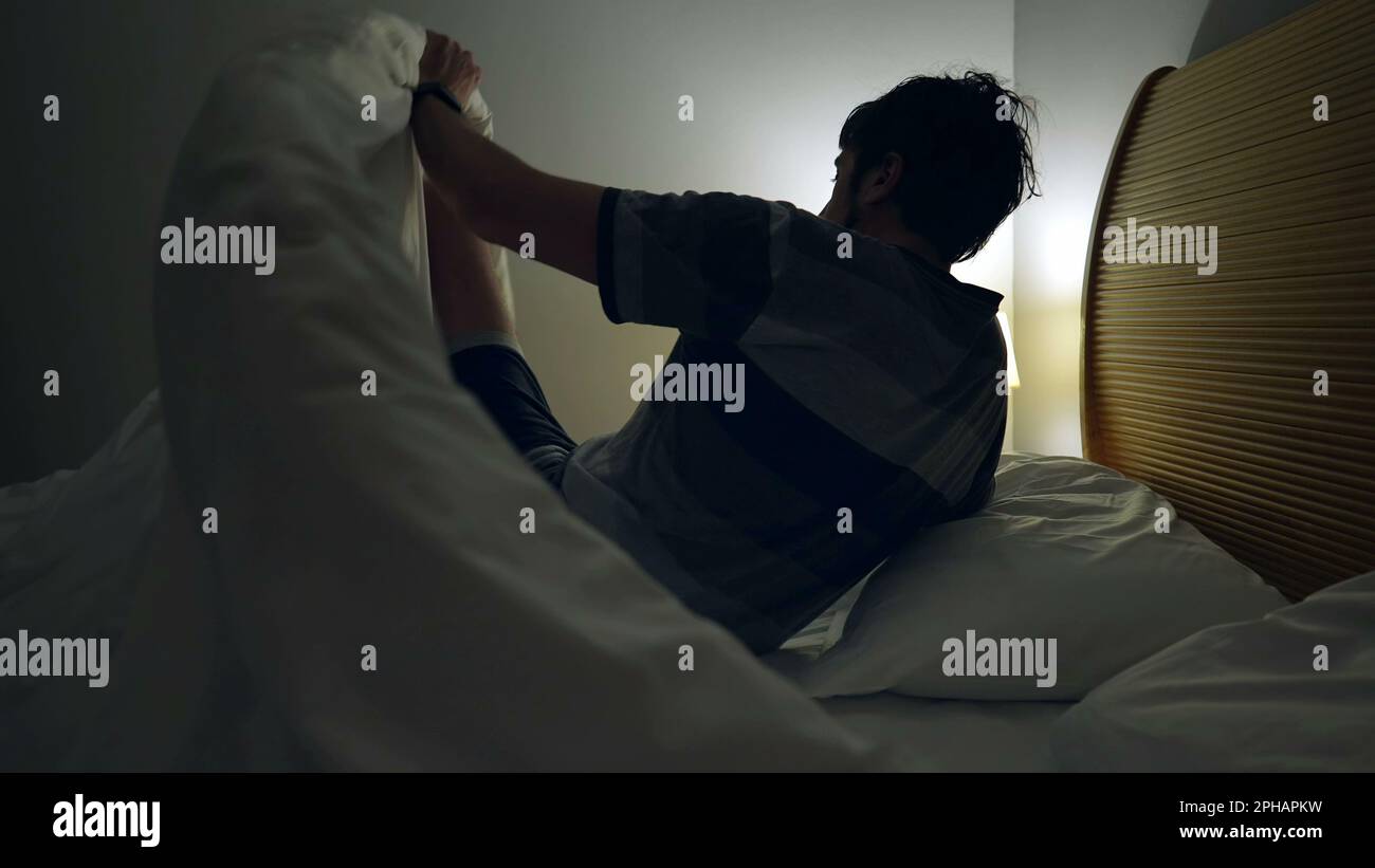 Homme allongé au lit pour se reposer après une longue journée. Personne ...