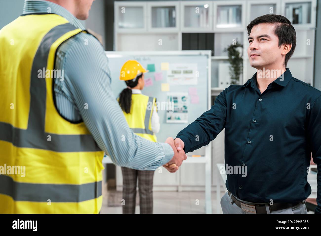 Un ingénieur avec une poignée de main protectrice avec un investisseur ...