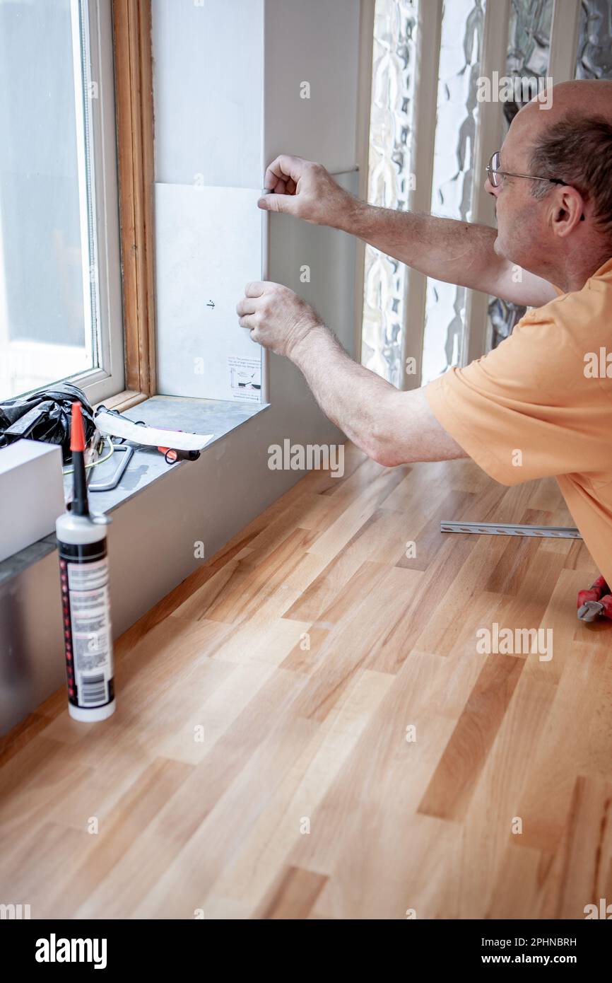 Appareils de cuisine : montage de la splashback. Un monteur prenant ...