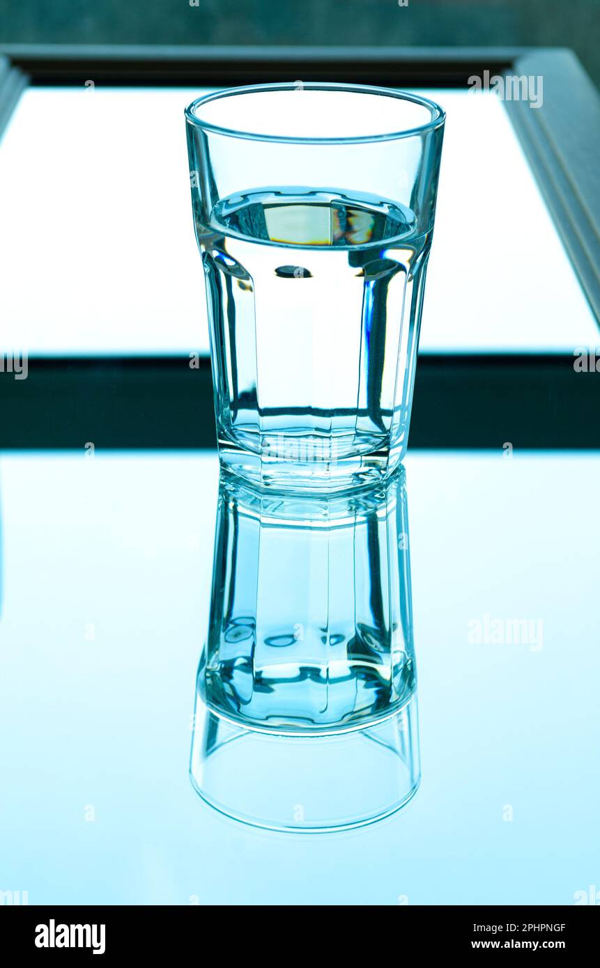 Reflet d'un verre d'eau de source dans le miroir Photo Stock - Alamy