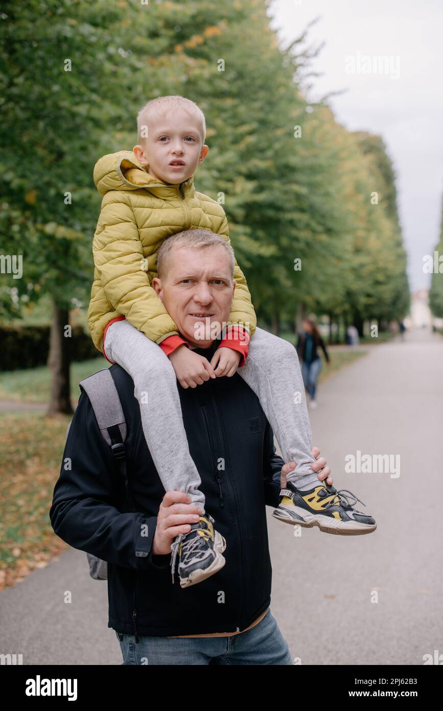 Papa tient sur les épaules de son fils. Une belle famille passe du ...