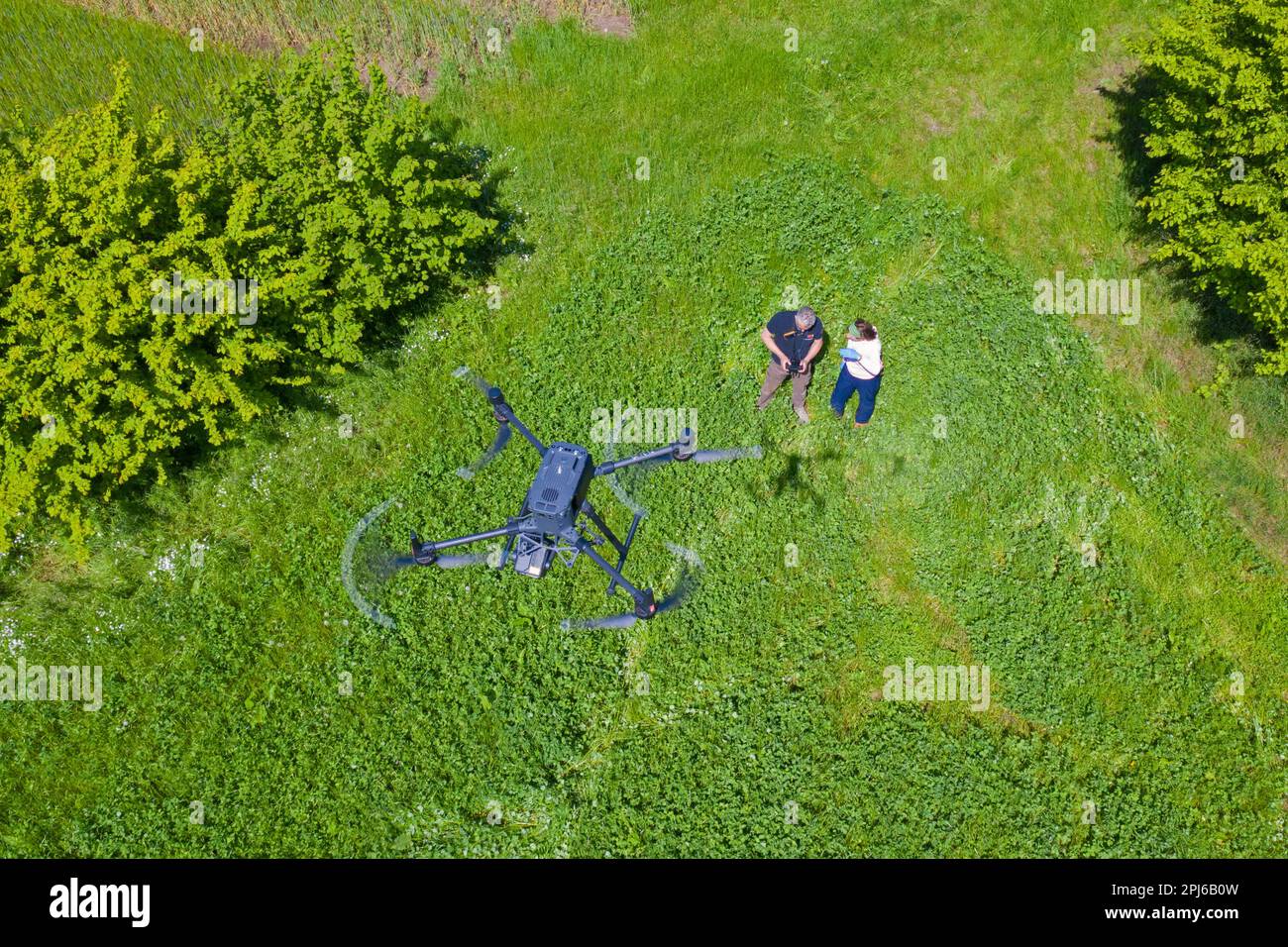 L'équipe de secours utilise un drone volant au-dessus d'une prairie ...