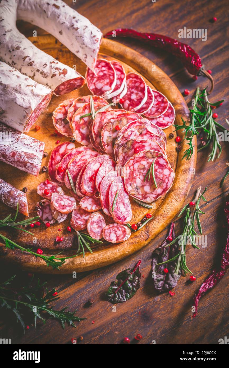 Charcuterie - assortiment de salami et de saucisses séchées à l'air sur planche à découper en ...