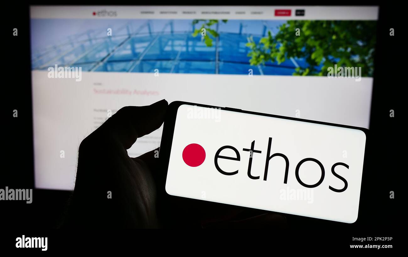 Personne tenant un téléphone portable avec le logo de l'institution financière suisse Ethos ...