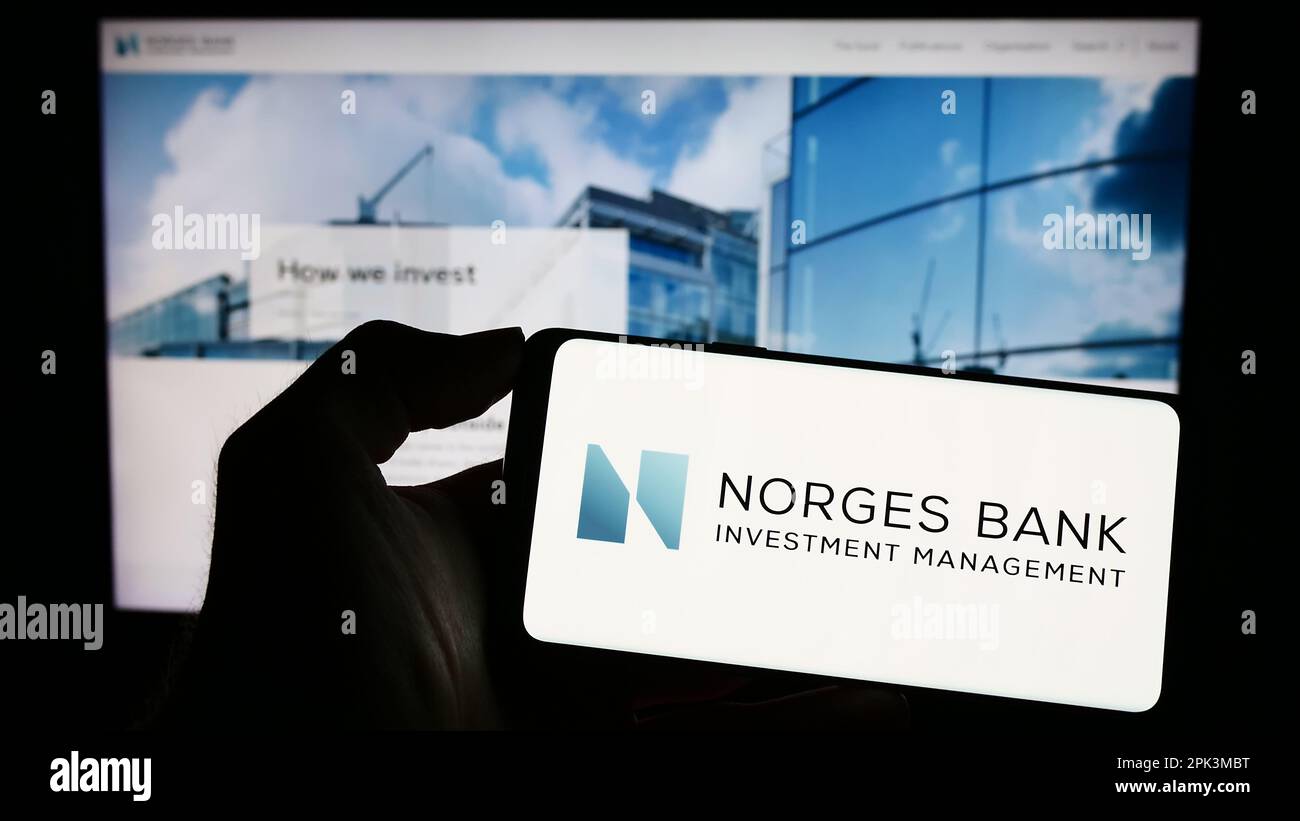 Personne tenant un téléphone cellulaire avec le logo de la Banque ...