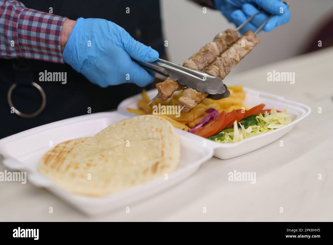 Le chef a mis de la viande grillée dans une boîte à lunch avec un plat ...