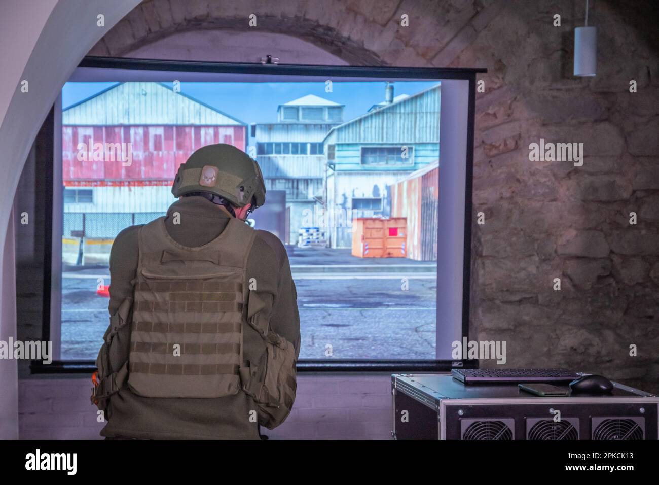 Un militaire en uniforme tient une arme dans ses mains et tire à une ...