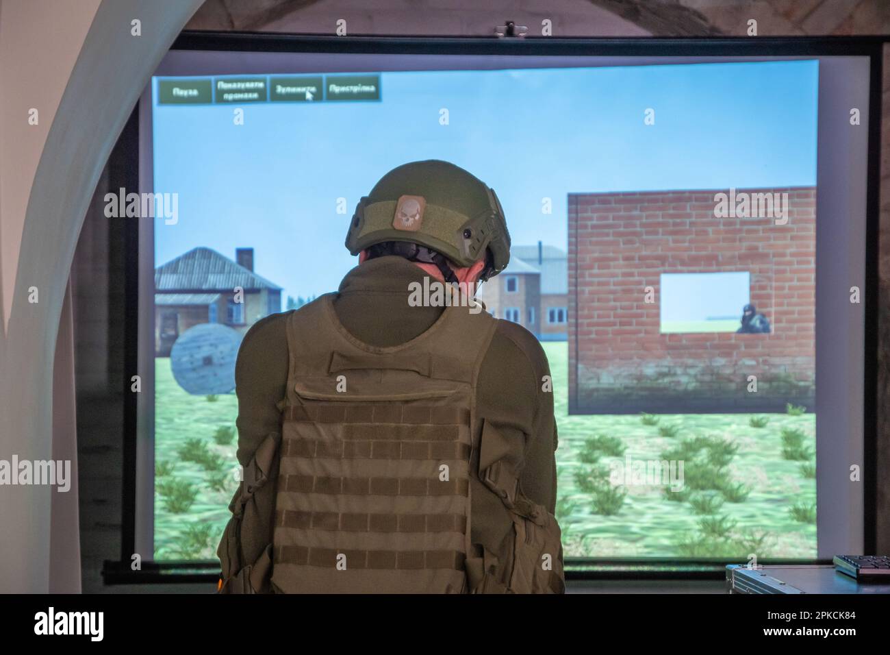 Un militaire en uniforme tient une arme dans ses mains et tire à une ...