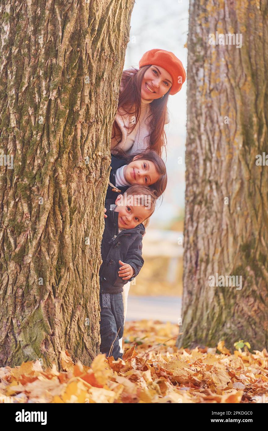 Se cacher derrière l'arbre. Mère avec son petit fils et sa fille s ...