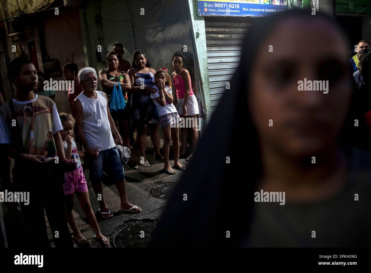 Residents watch a Way of the Cross reenactment at the Complexo do ...