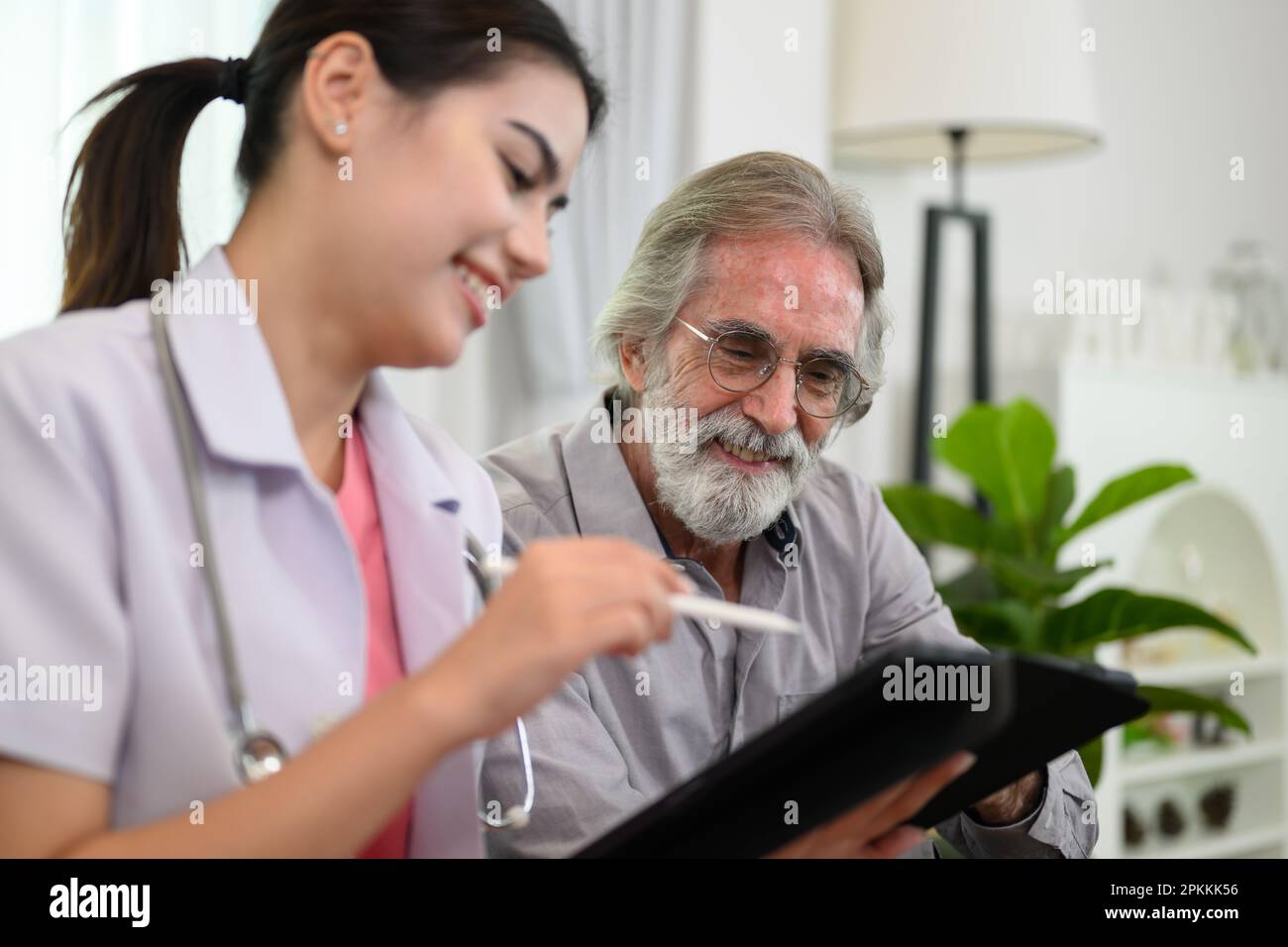 Médecin ou infirmier soignant avec un patient âgé à domicile ou en ...