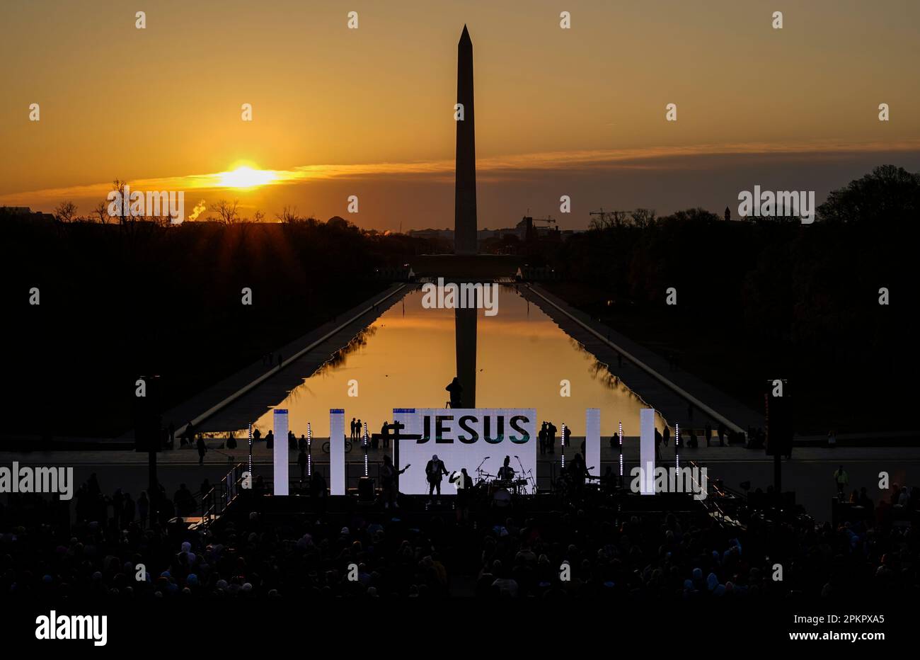 "Jesus" is displayed on a large monitor and worship songs are played on ...