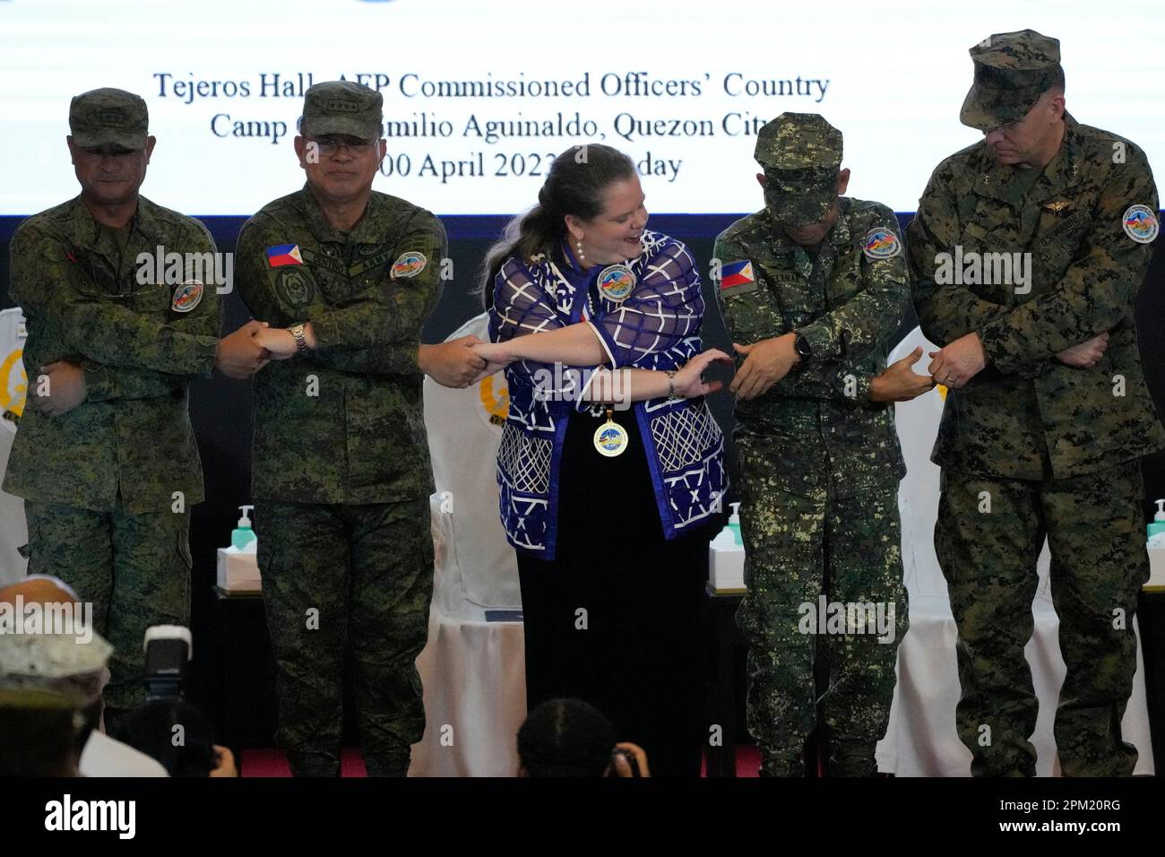 U.S. Charge d'affaires Heather Variava, center, link-arms with ...