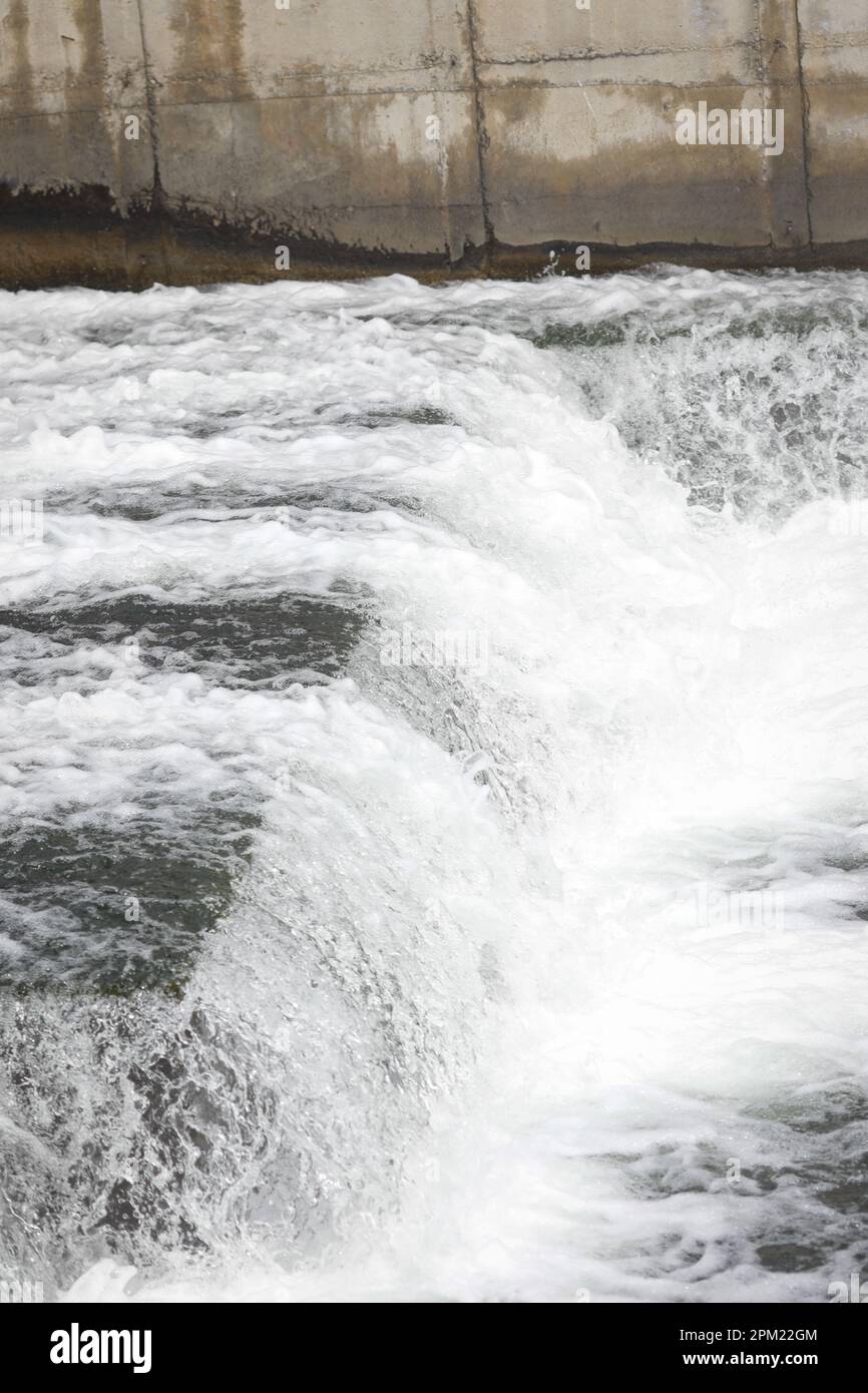 Eau qui coule à travers un bidonville sur une rivière en béton ...