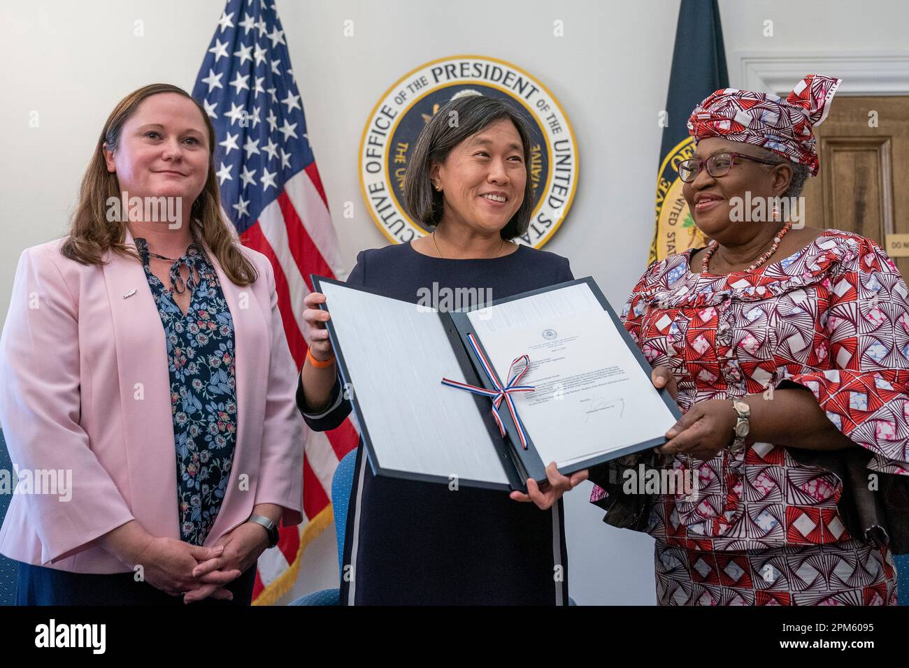 U.S. Trade Representative Katherine Tai, center, holds a signed World ...