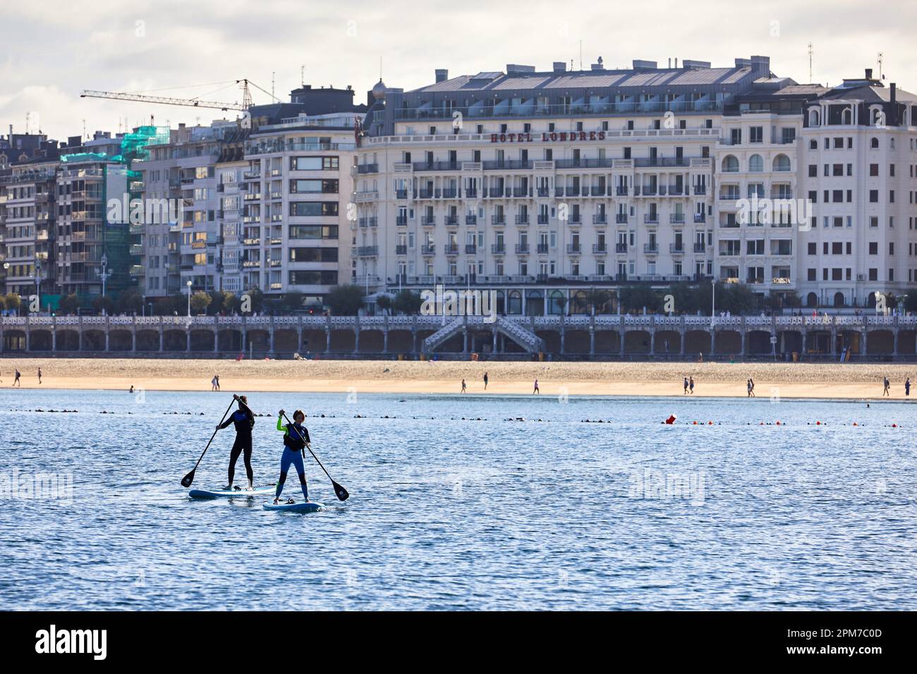 Couple de touristes pratiquant le paddle-surf dans la baie de la Concha ...
