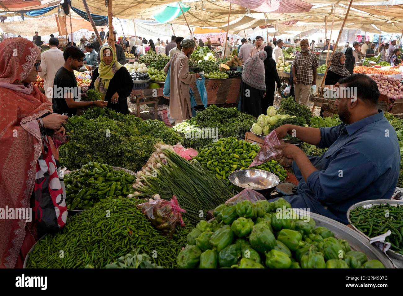 People buy vegetables at a bazaar, setup by provincial government to ...