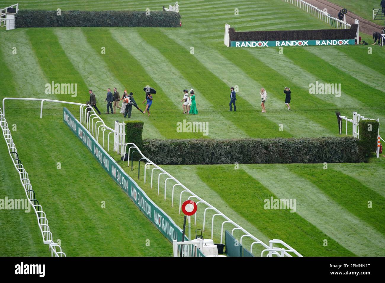 Les Racegoers traversent la piste sous des parapluies devant le Service ...