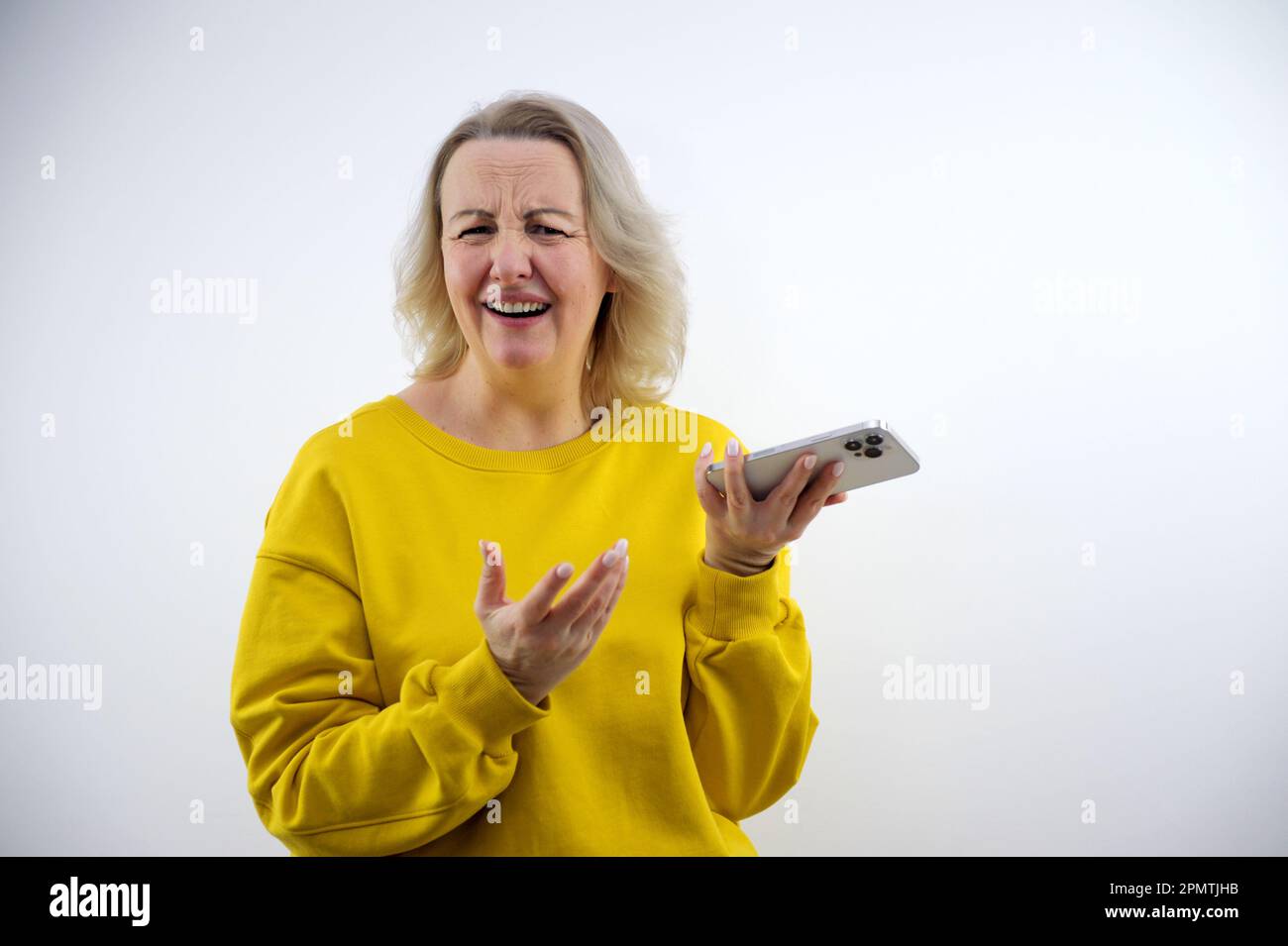 Portrait d'une femme excitée qui lit un message sur un smartphone, qui utilise un appareil ...