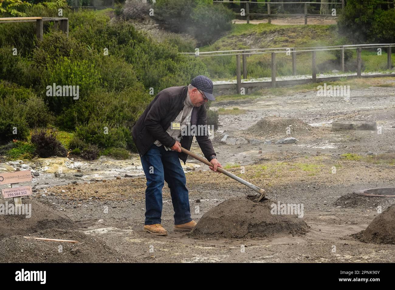 Un ouvrier commence à découvrir le sable volcanique d'une fosse ...